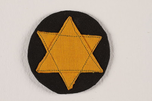Badge with a yellow Star of David on a black circle worn by a Romanian ...